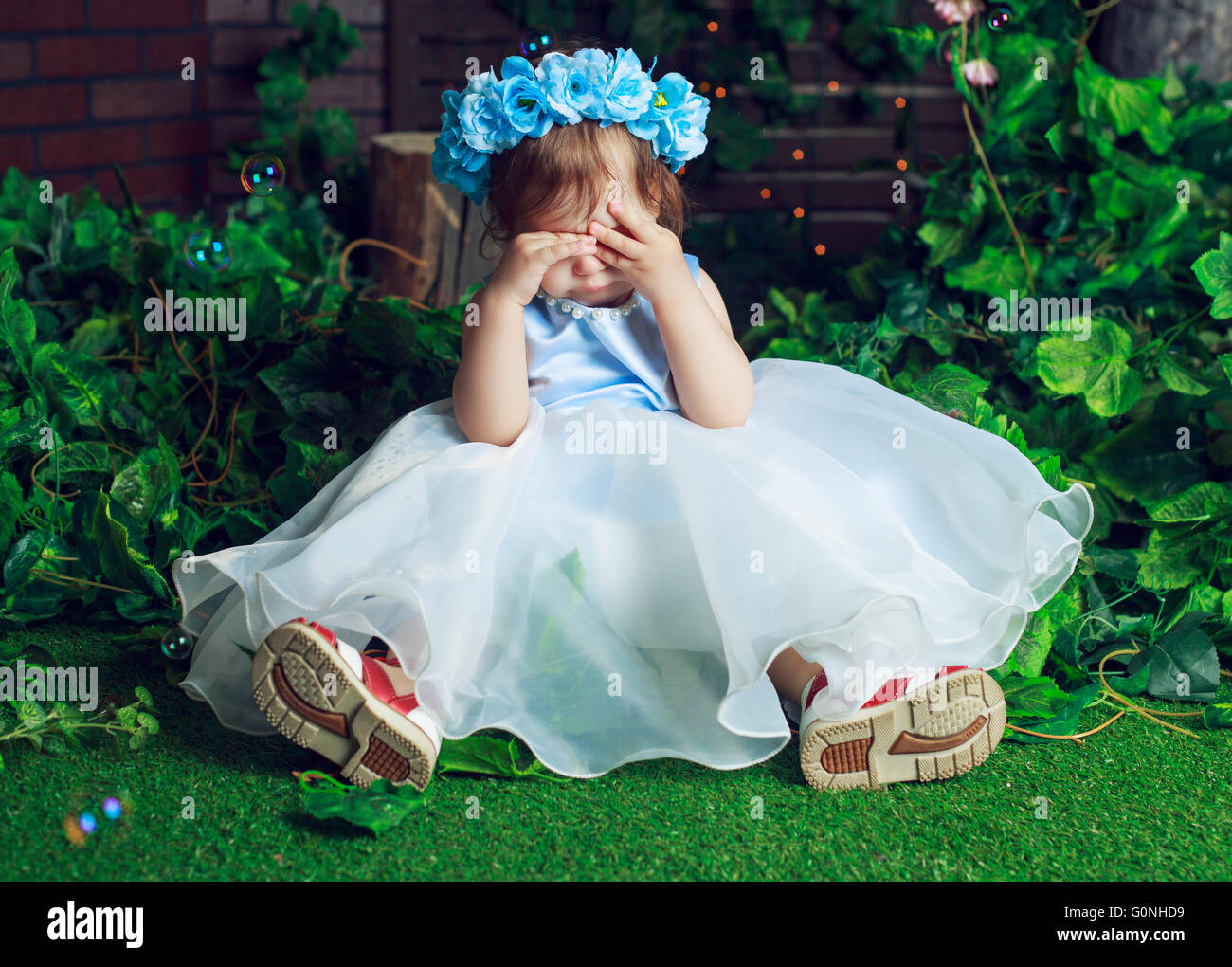 crying baby wearing a flower crown in the forest Stock Photo - Alamy