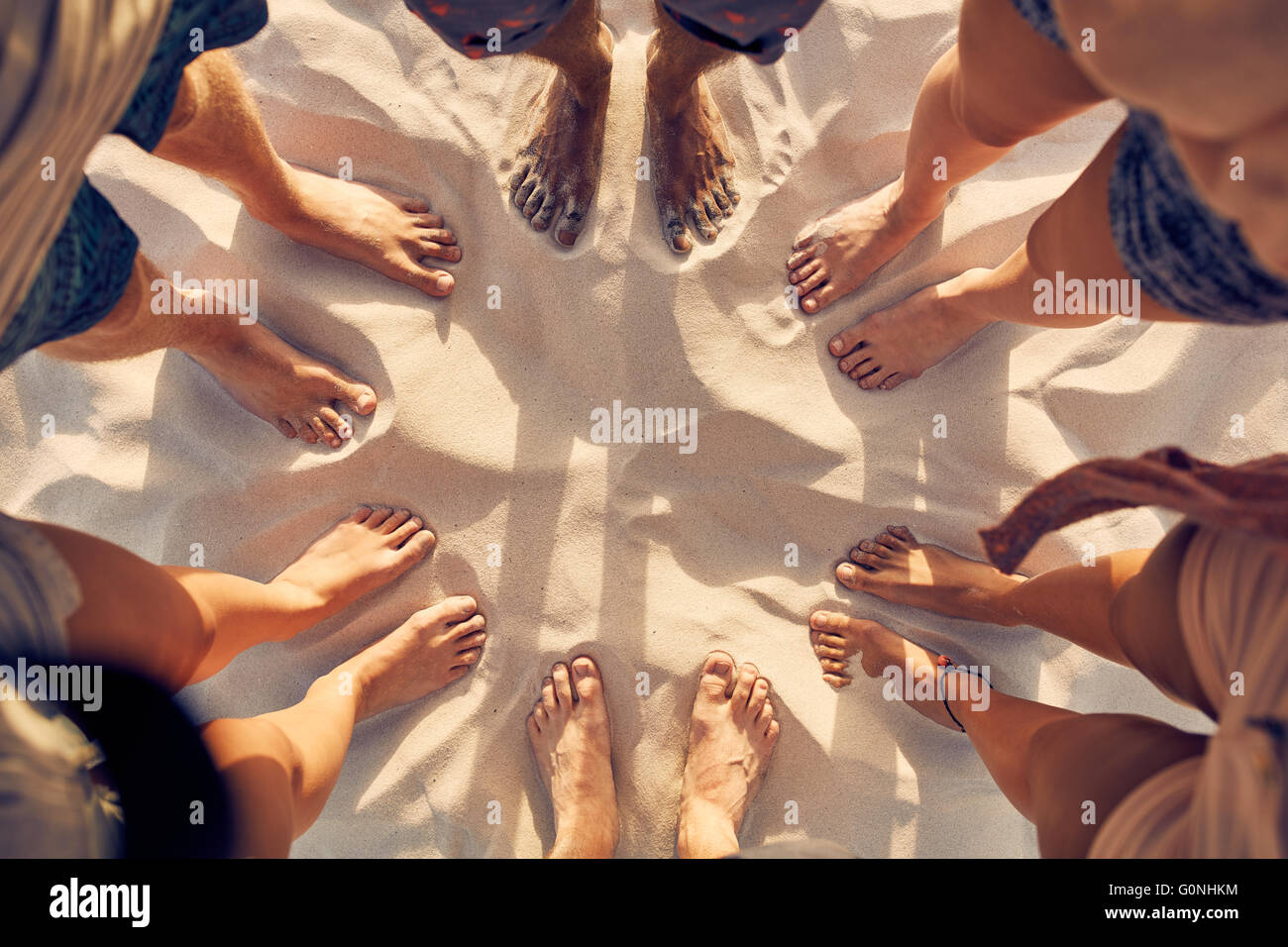 Top view image of feet of young people standing in a circle. Mixed race ...