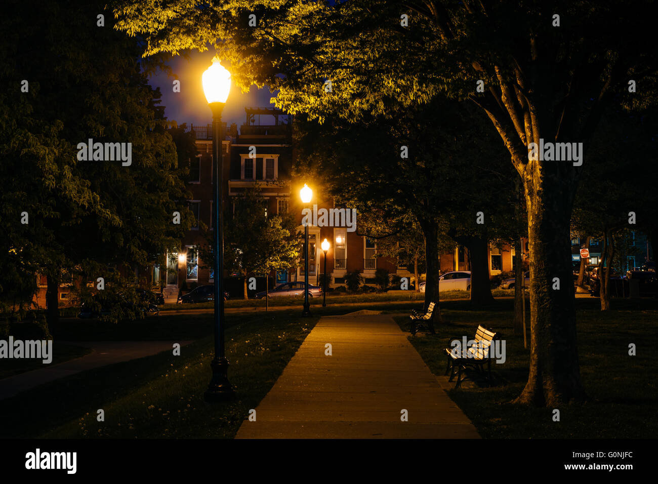 Bench and walkway at Federal Hill Park at night, in Baltimore, Maryland ...
