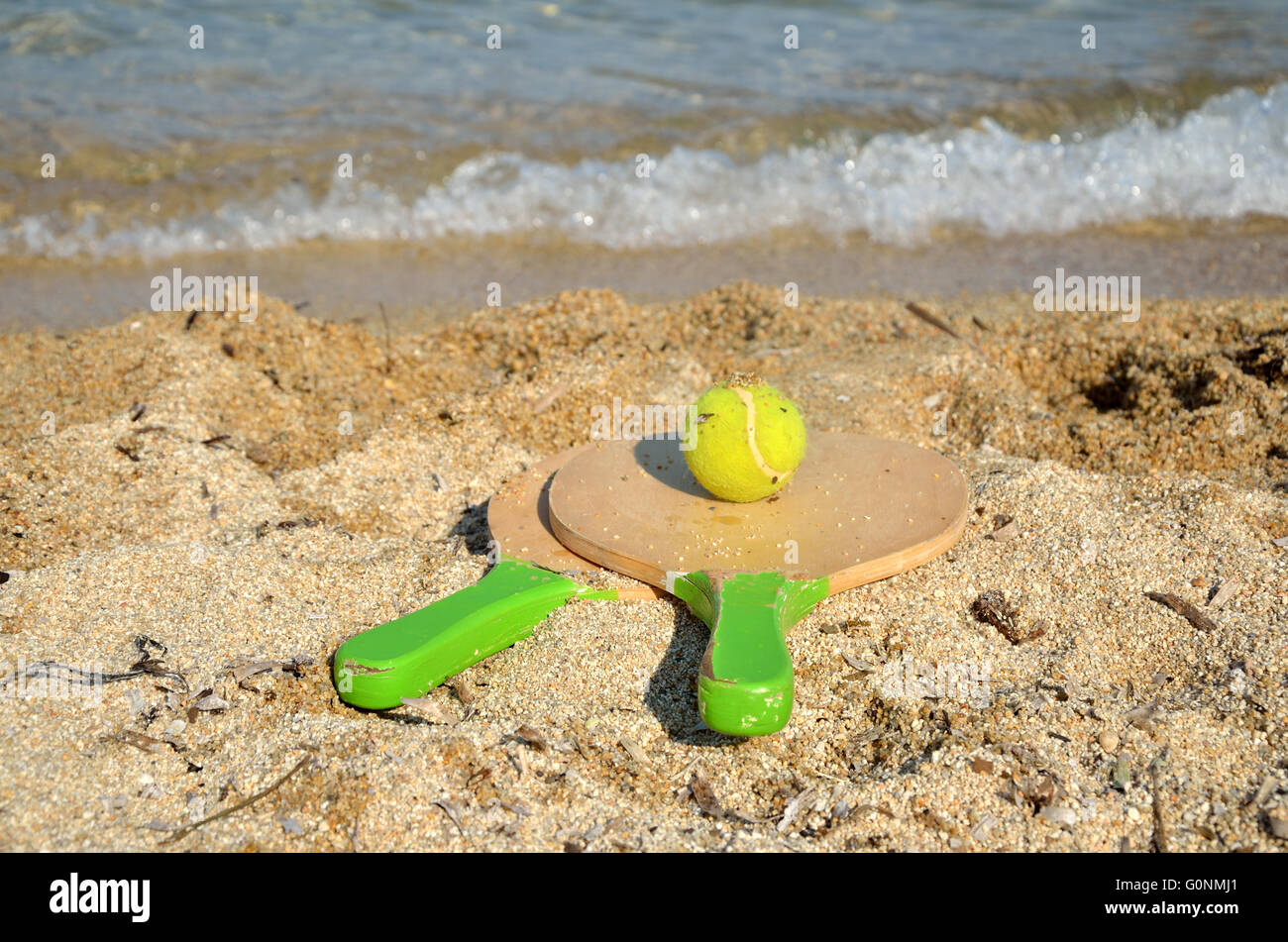 Pair of rackets and ball for sport on the beach Stock Photo - Alamy