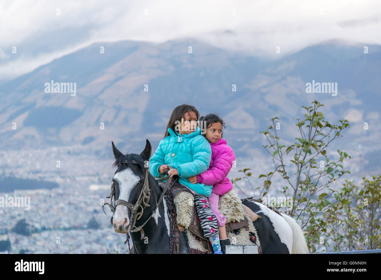 QUITO, ECUADOR, OCTOBER - 2015 - Two indigenous ecuadorian girls riding ...