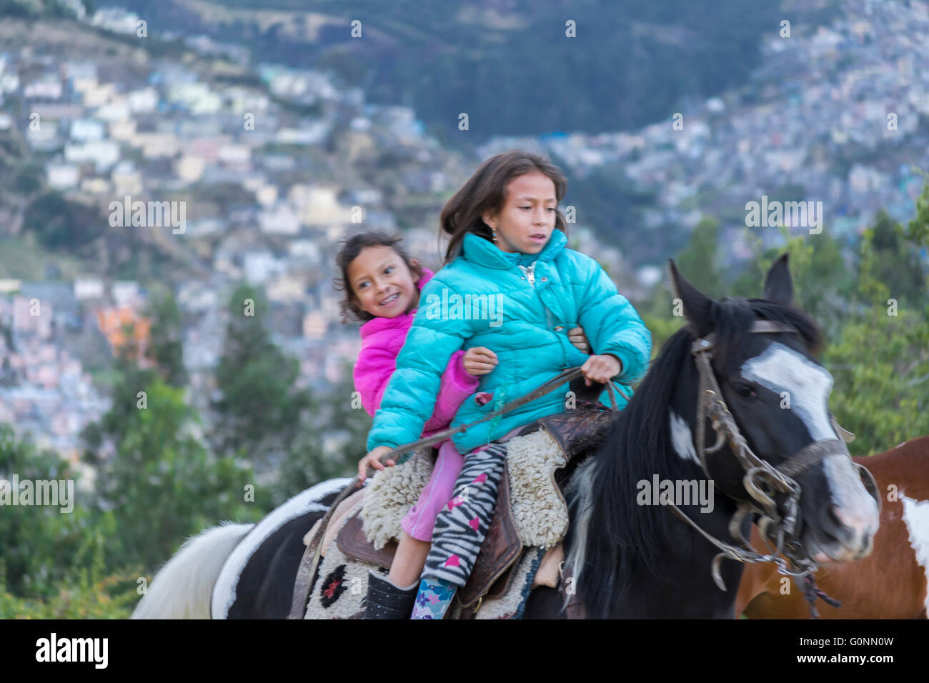 QUITO, ECUADOR, OCTOBER - 2015 - Two indigenous ecuadorian girls riding ...