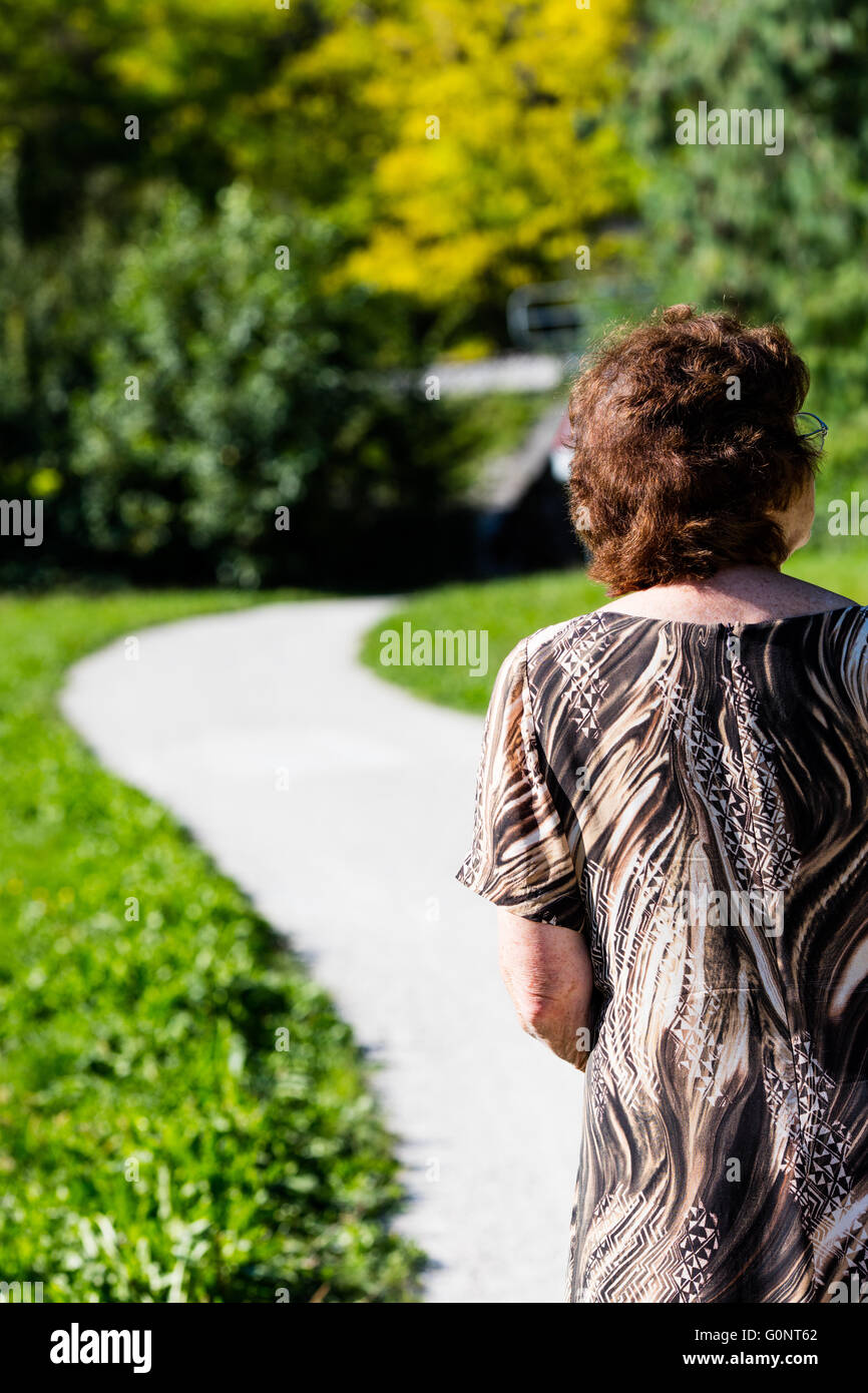 old woman walking on a path in the green grass (no face visible Stock ...