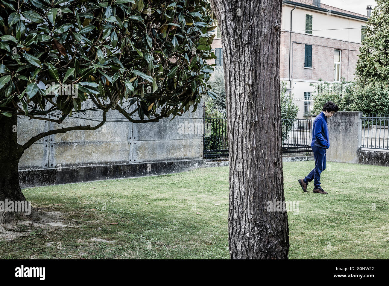 young boy deep in thought walking alone in garden Stock Photo - Alamy