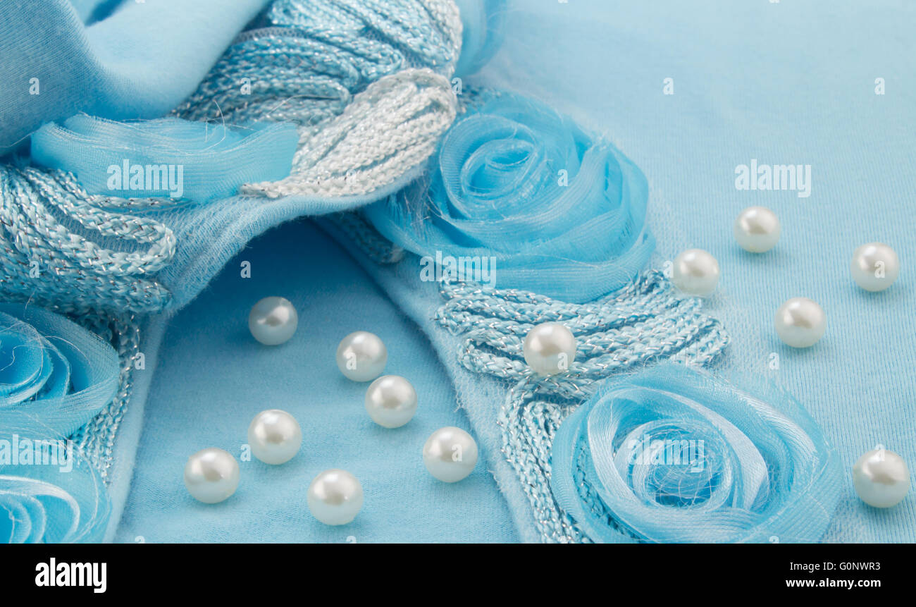 White pearls scattered on turquoise ribbon and silver cord with fabric ...