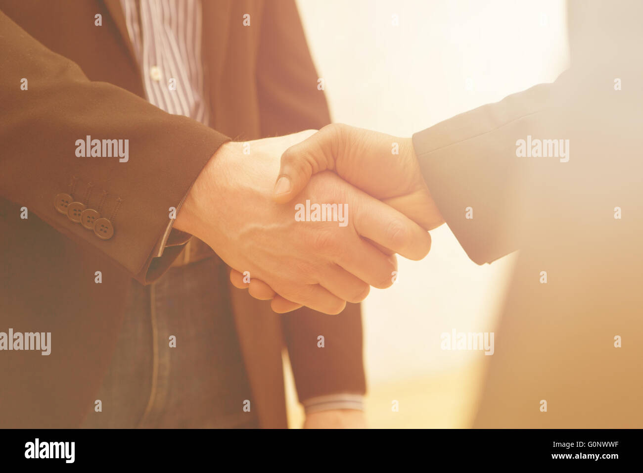 Business handshake with sun rays Stock Photo - Alamy