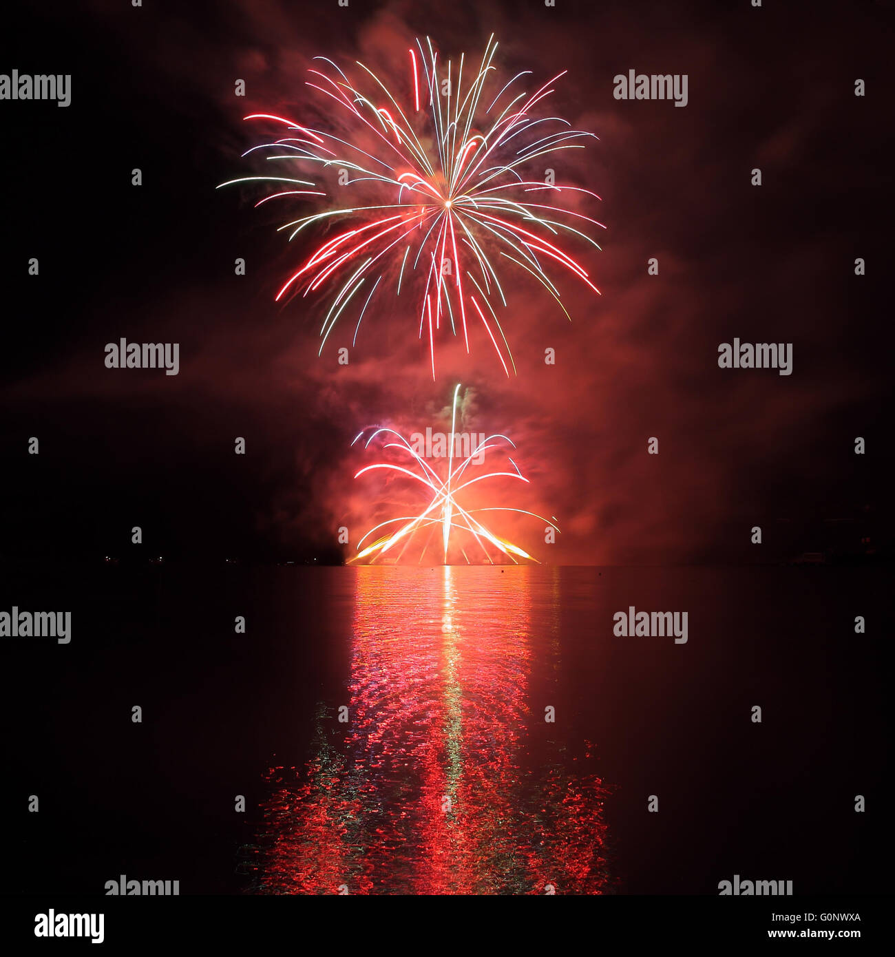 Colorful fireworks with reflection on lake and night sky in background ...