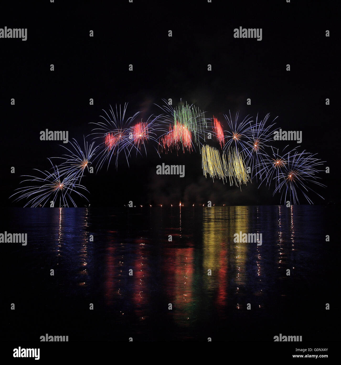 Colorful fireworks with reflection on lake and night sky in background ...