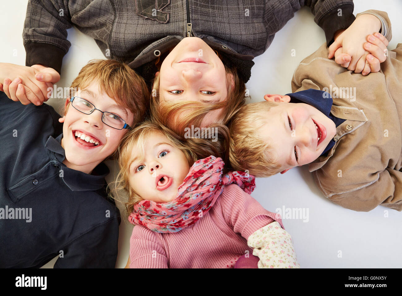Four happy siblings in a circle looking up Stock Photo - Alamy