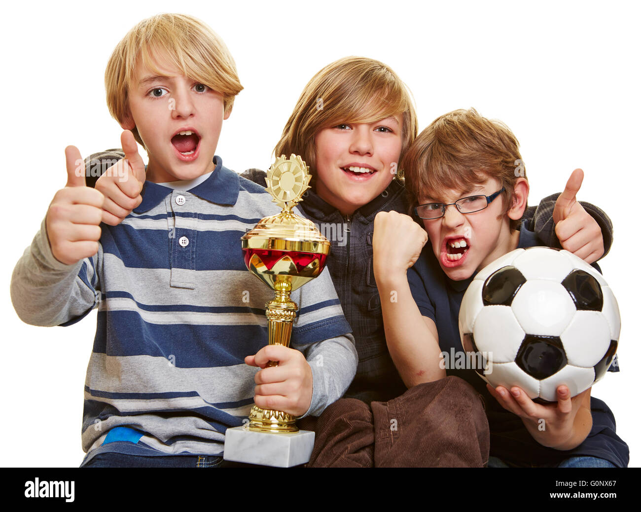 Three cheering boys with trophy and soccer ball holding their thumbs up ...