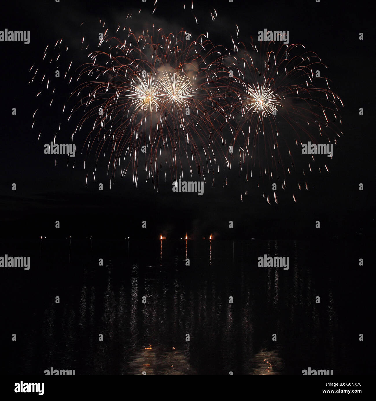 Colorful fireworks with reflection on lake and night sky in background ...