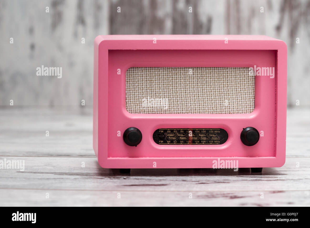 Pink radio with retro look on white wooden background Stock Photo - Alamy
