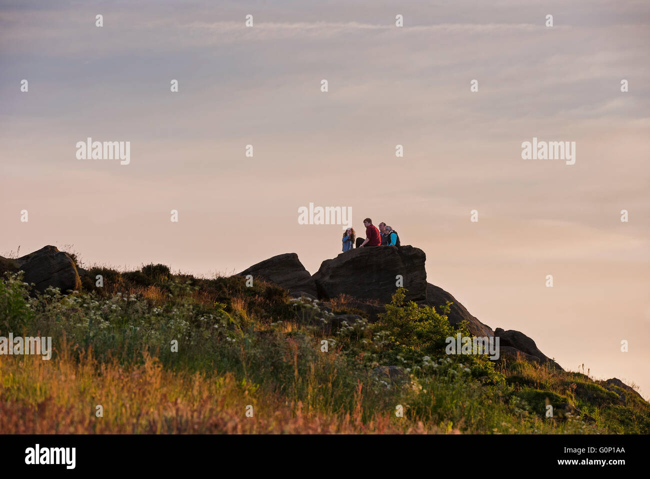 Family of four sit perched, high on a rocky outcrop, to admire the view ...