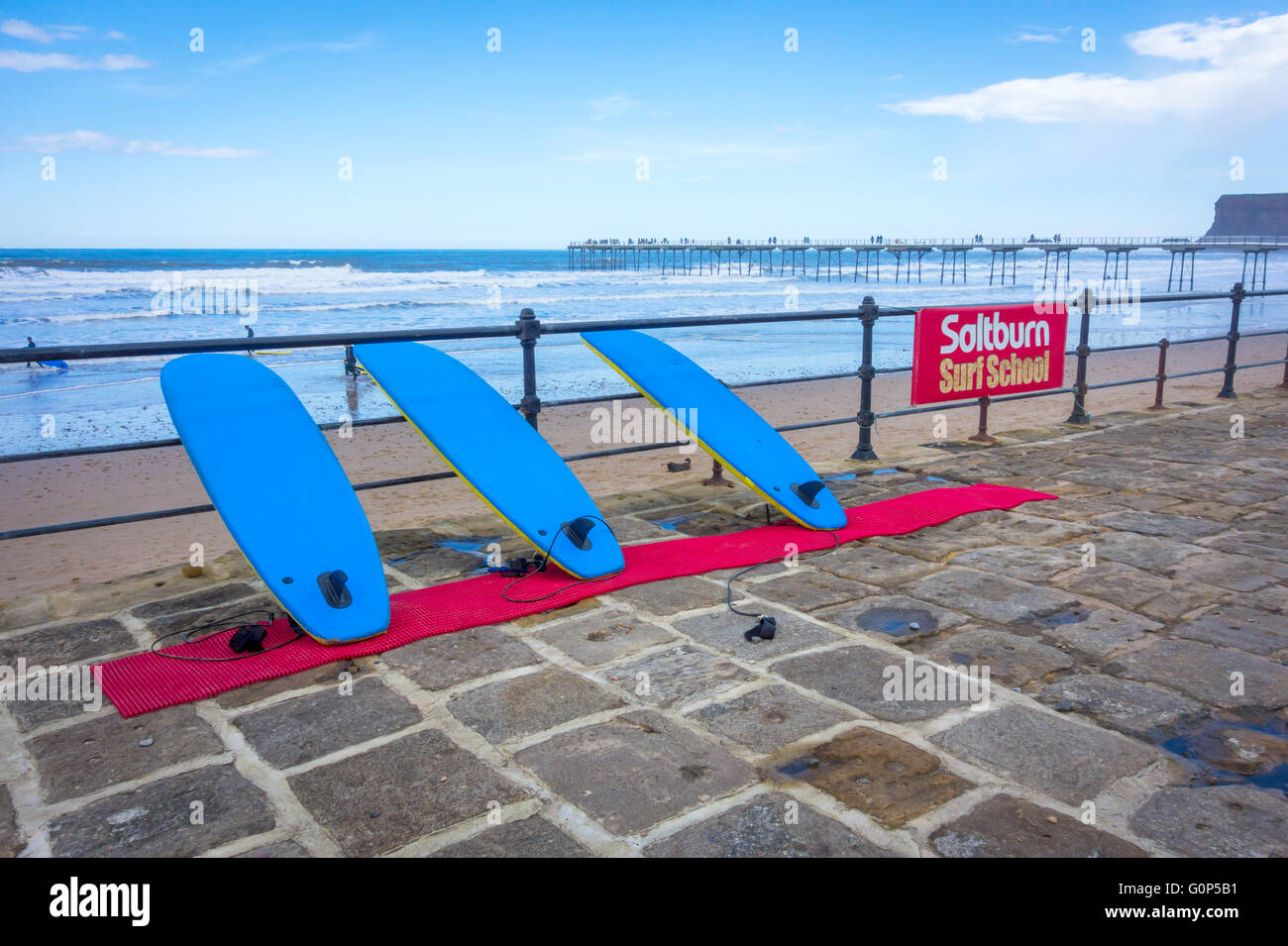 Sign for Saltburn Surf School on the promenade railings with surf ...