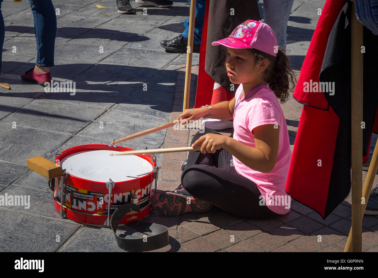 Small girl plays a drum at a workers' protest Mayday gathering in ...
