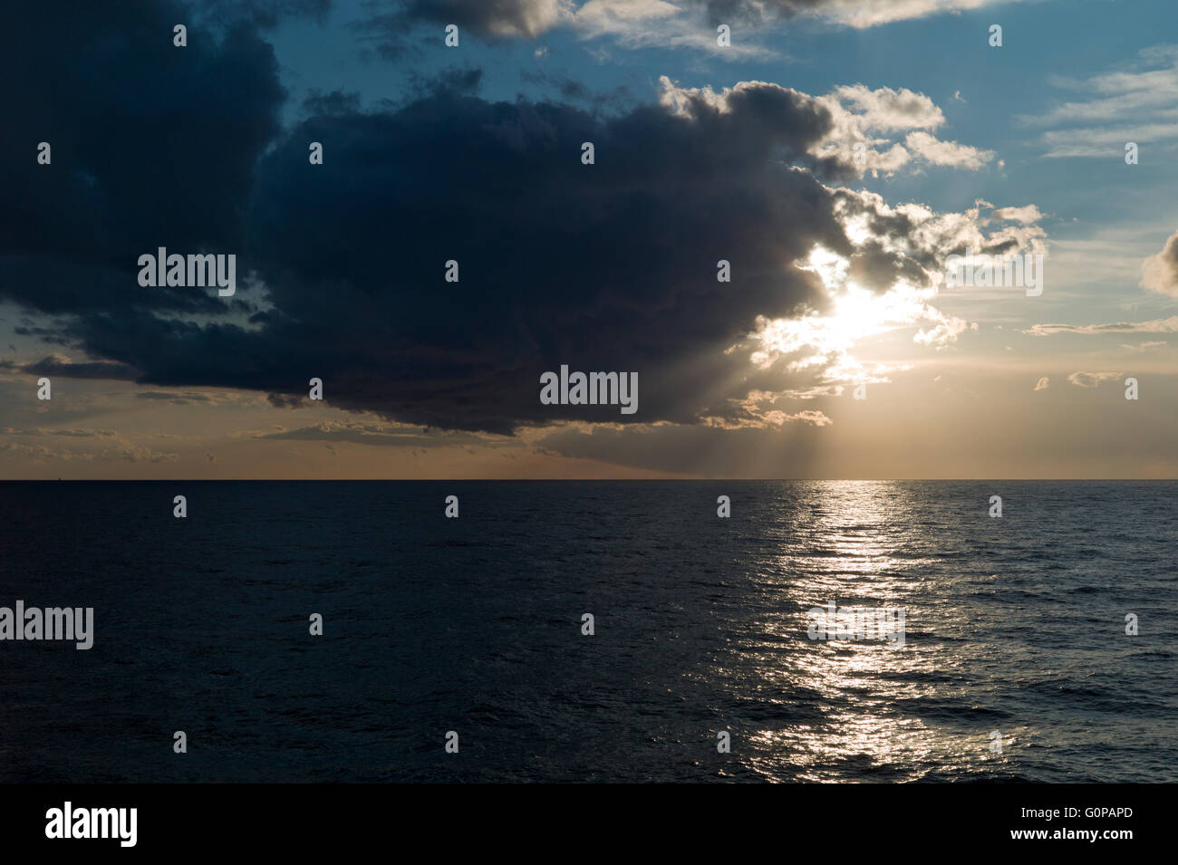 Dark clouds hiding sun over sea Stock Photo - Alamy