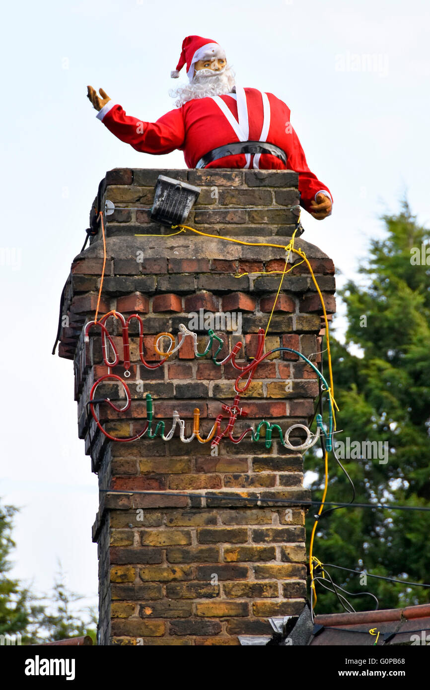 Father Christmas on the top of a real lived in house chimney stack with ...