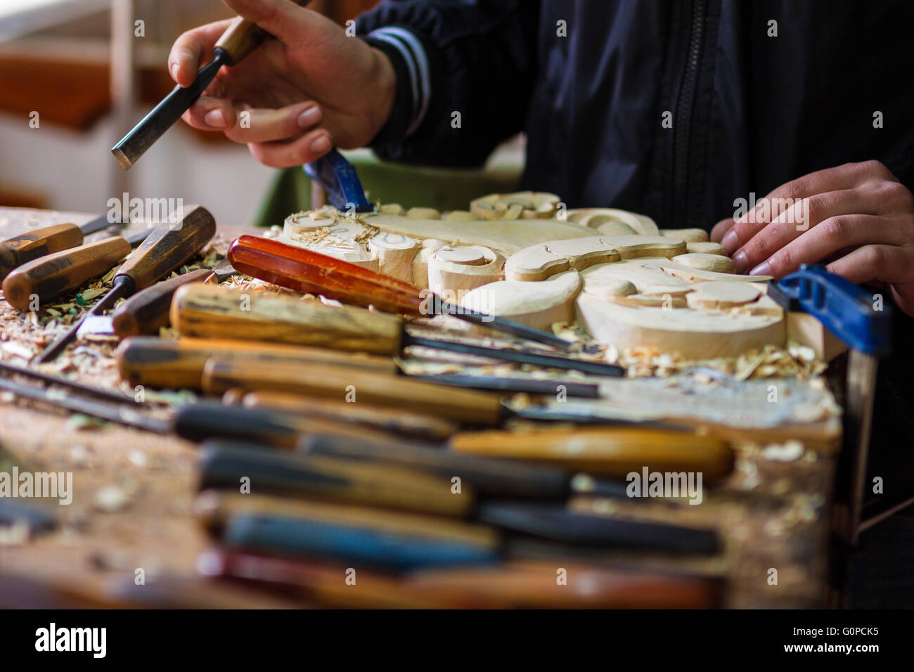 Carpenter hand carving wood with care. Hand with tool blured in motion ...
