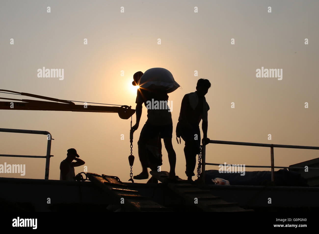 Yangon, Myanmar. 3rd May, 2016. A laborer carries a bag of rice at a ...