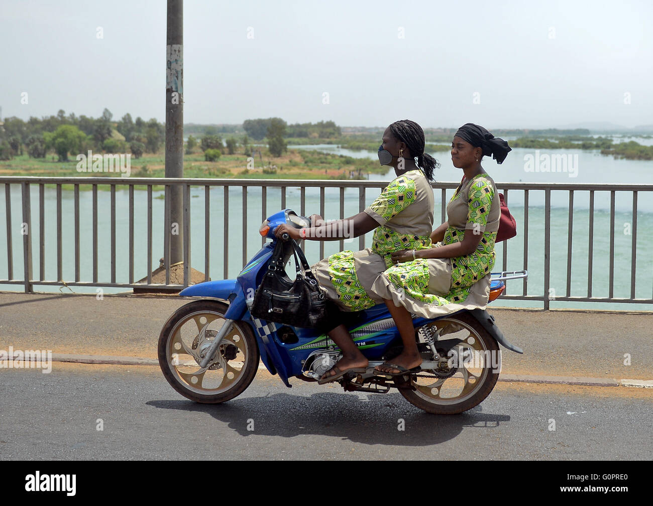Bamako, Mali. 02nd May, 2016. Two women ride a moped over a bridge over ...