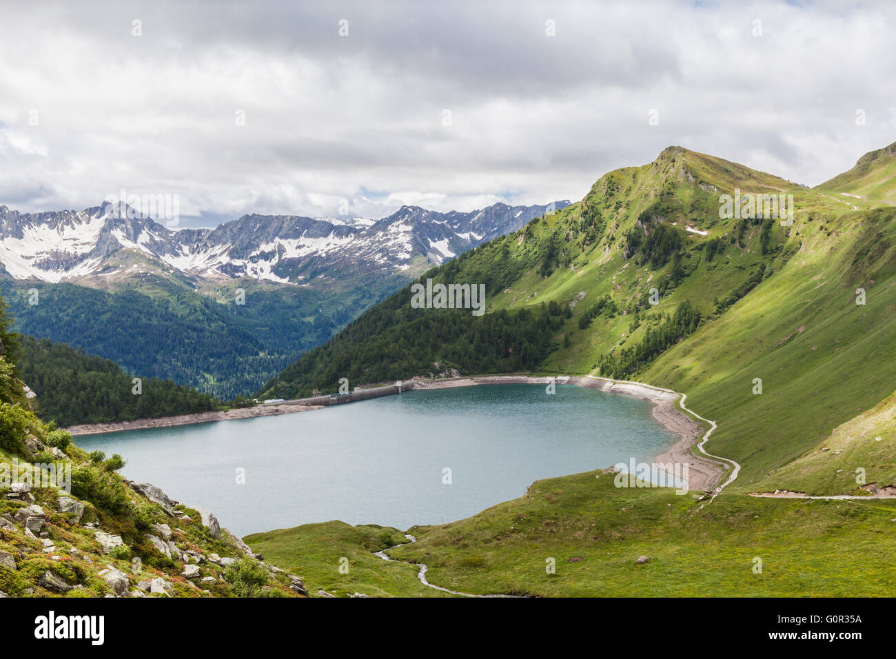 Stunning view of the lake of Ritom and the dam with the alps in ...
