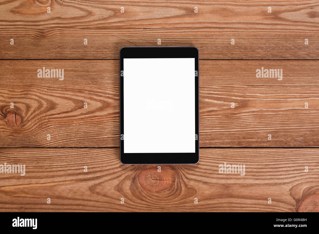 Black modern generic tablet with blank screen on wooden office desk ...