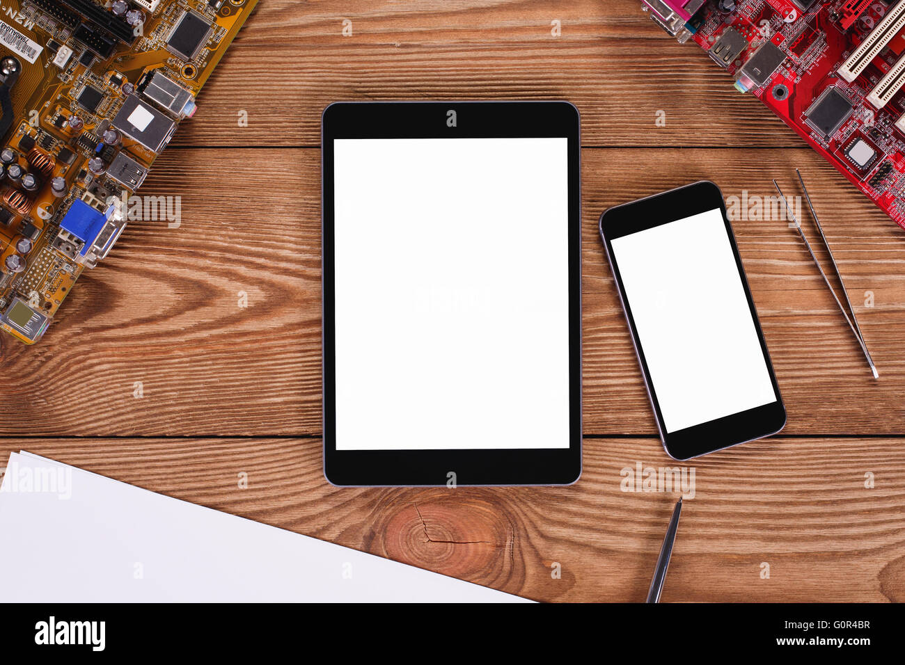 Black modern generic tablet and smartphone on wooden office desk next ...