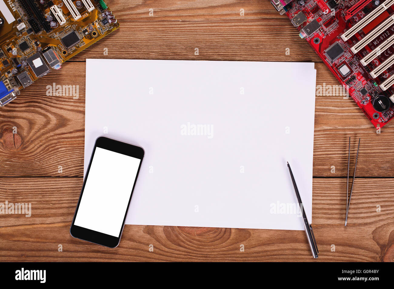 Modern generic black smartphone, paper and pen in the middle on wooden ...