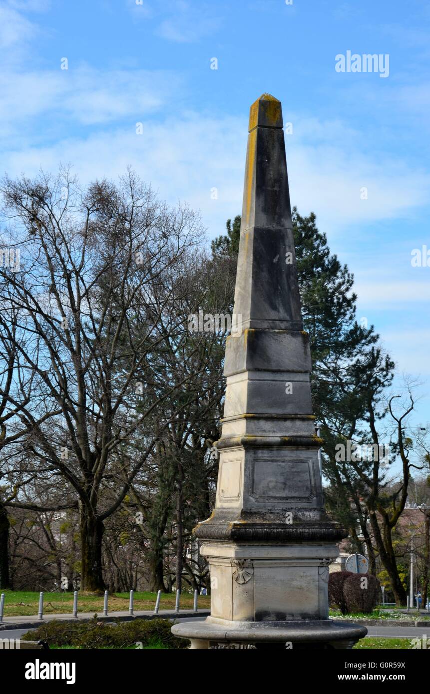 Memorial weathered obelisk on circular base at Mirogoj Cemetery Park ...