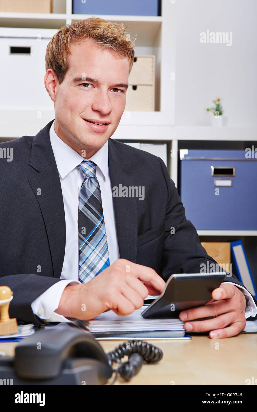 Business man with calculator in office doing financial analysis Stock ...