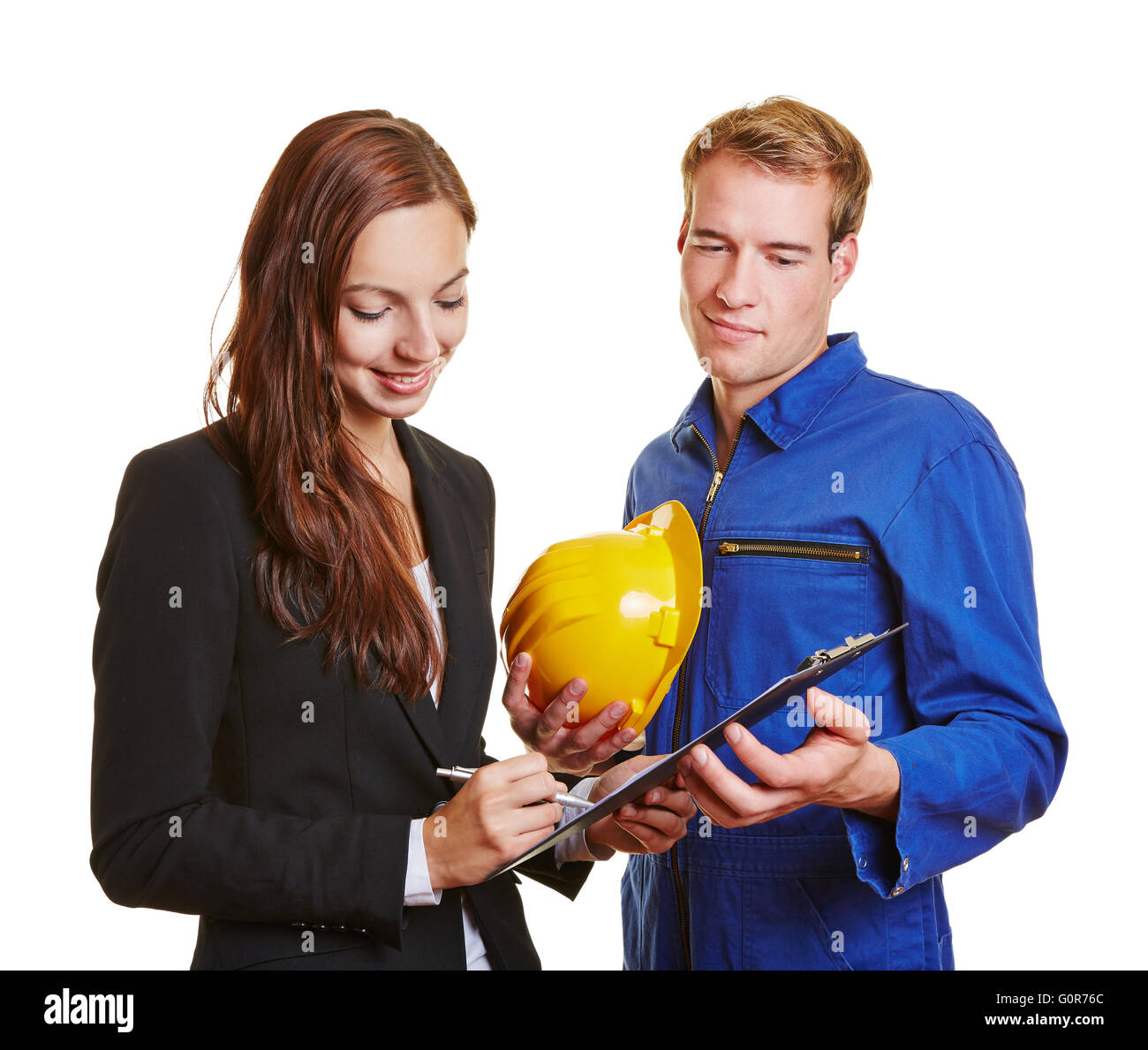 Businesswoman with construction worker signing contract on a clipboard ...