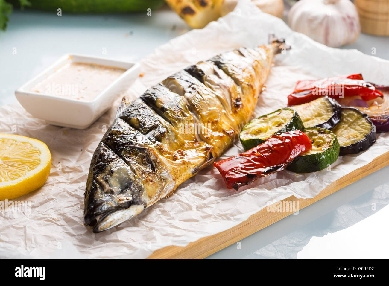 fish baked on the grill. with potatoes and lemon Stock Photo - Alamy