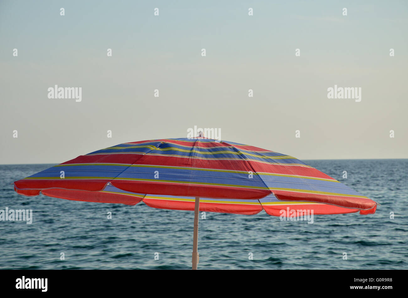 Colorful parasol on beach and sea in background Stock Photo - Alamy