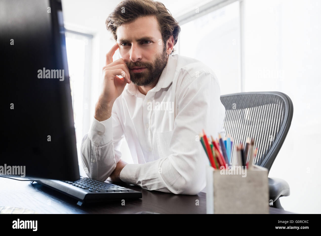 A pensive man looking at his computer Stock Photo - Alamy