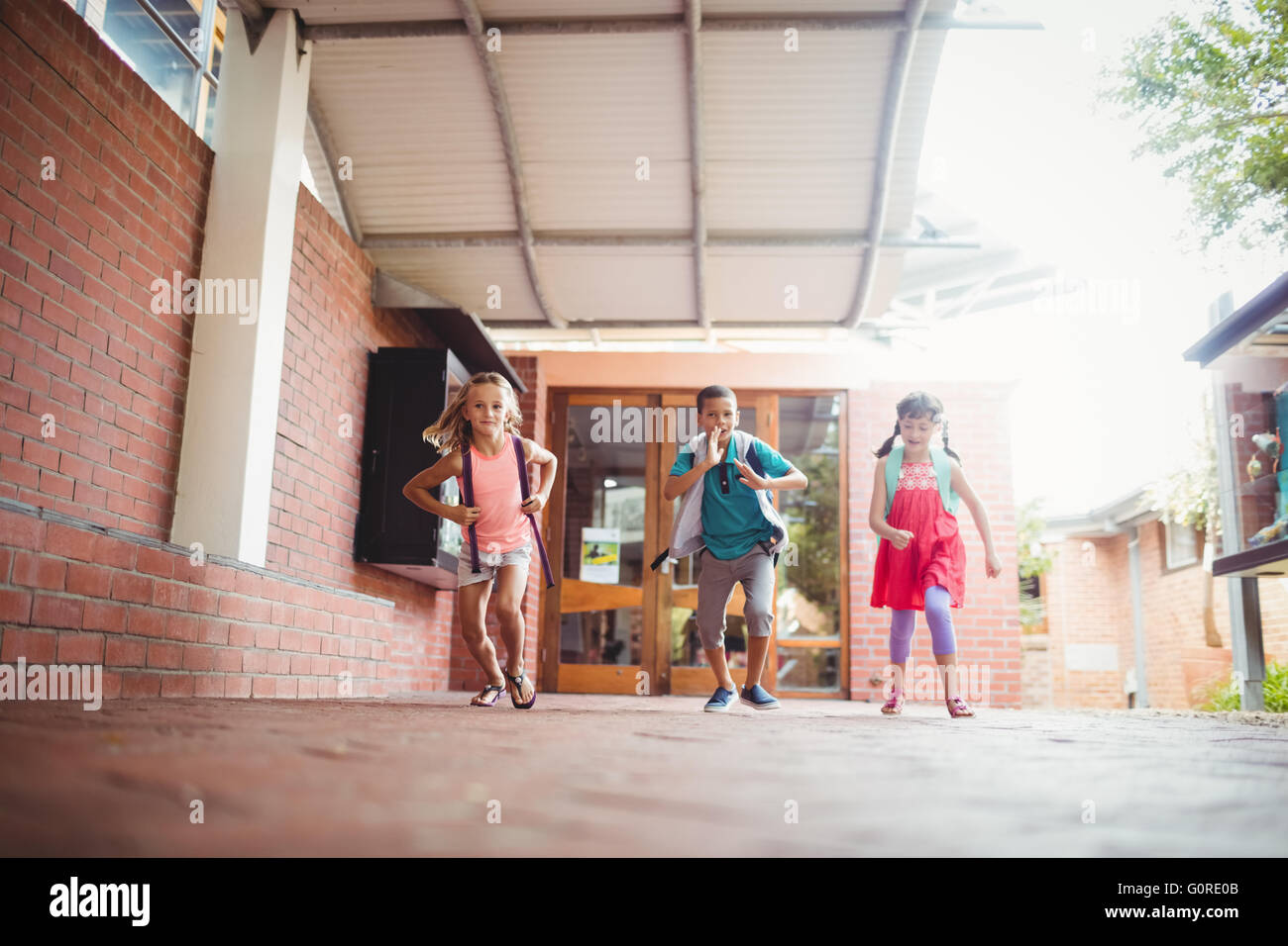 Three kids running in the playground Stock Photo - Alamy