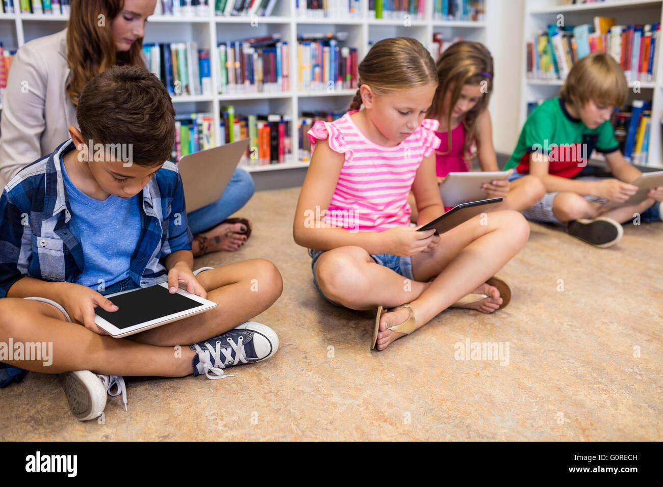 Teacher giving lesson to her students Stock Photo - Alamy