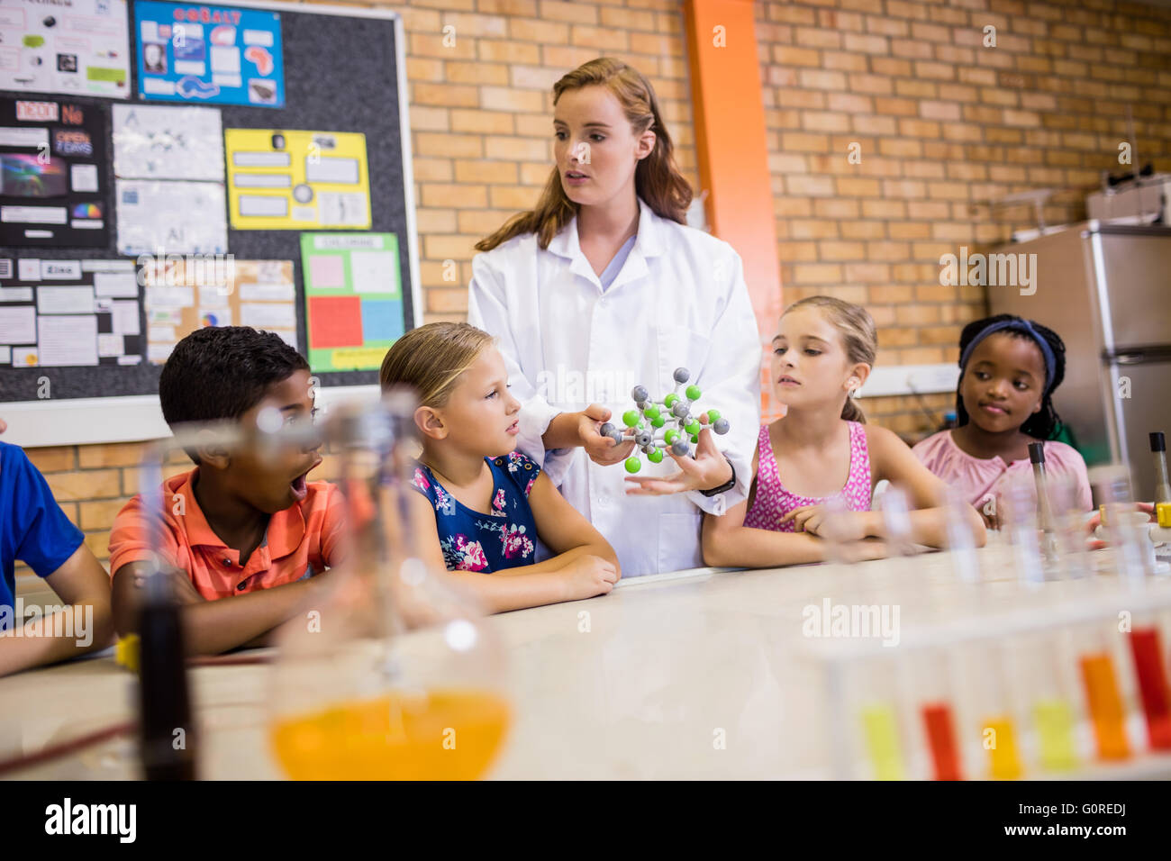 Teacher giving lesson to her students Stock Photo - Alamy
