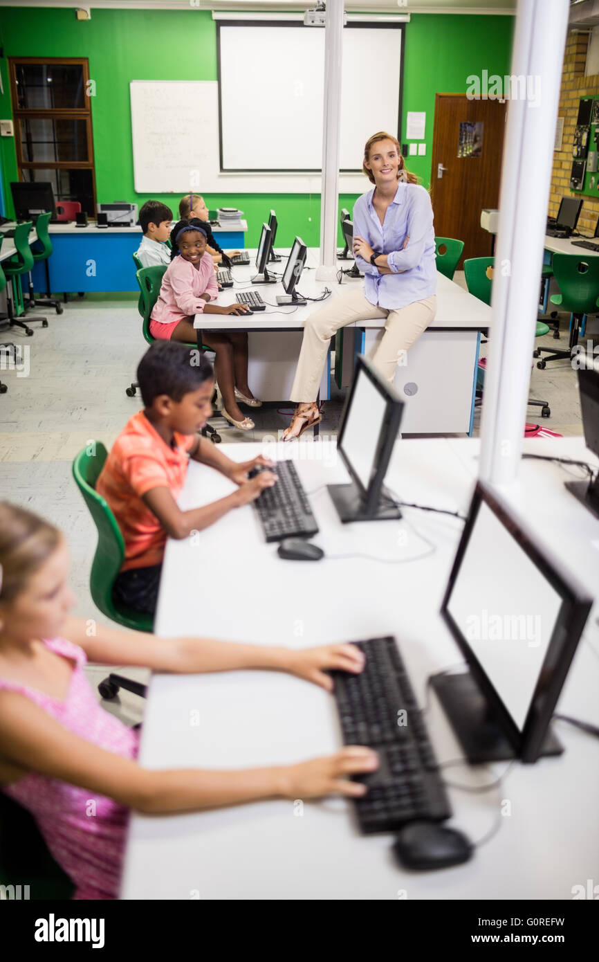 Teacher giving lesson to her students with technology Stock Photo - Alamy