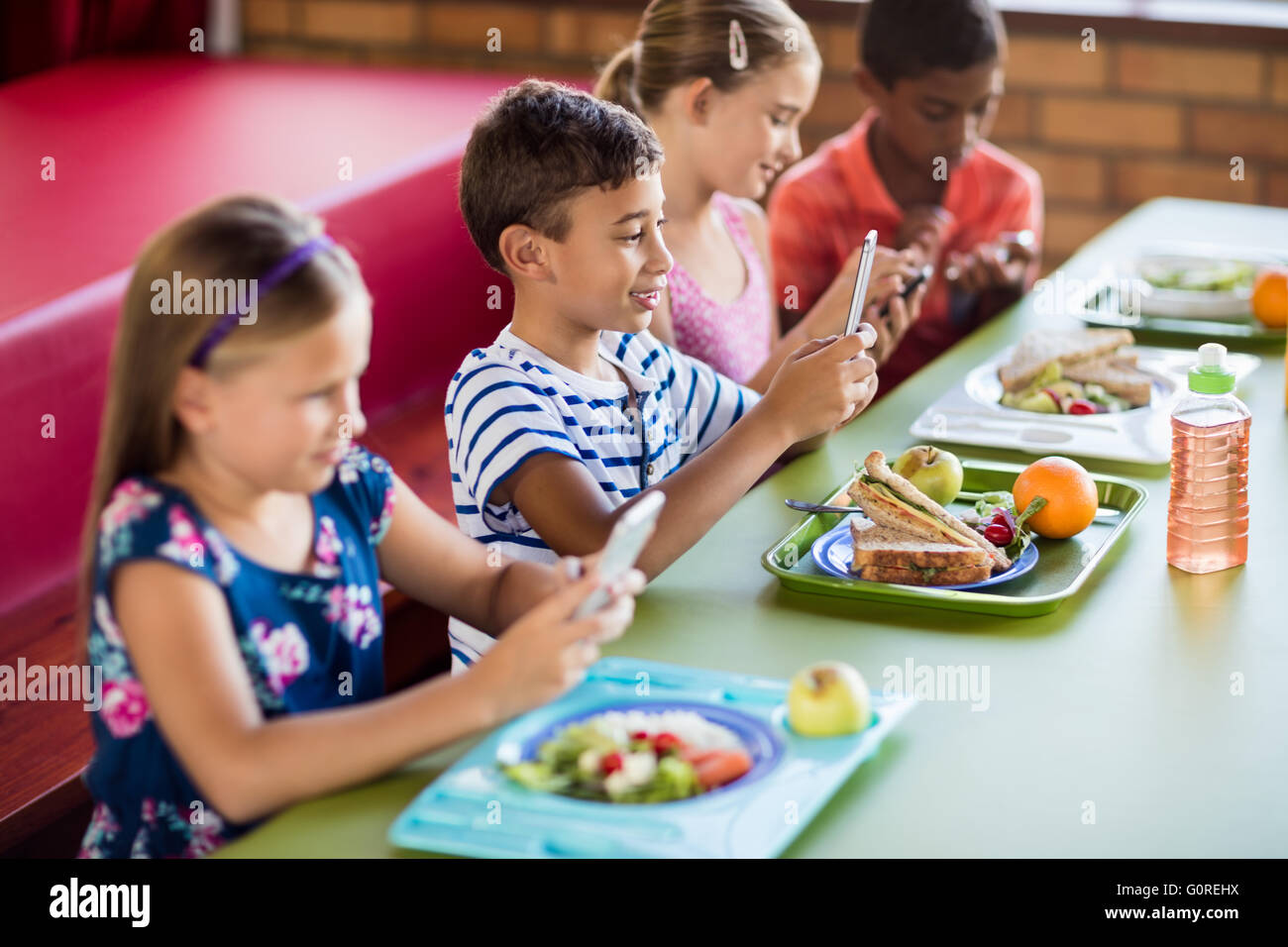 Children using technology during lunch Stock Photo - Alamy