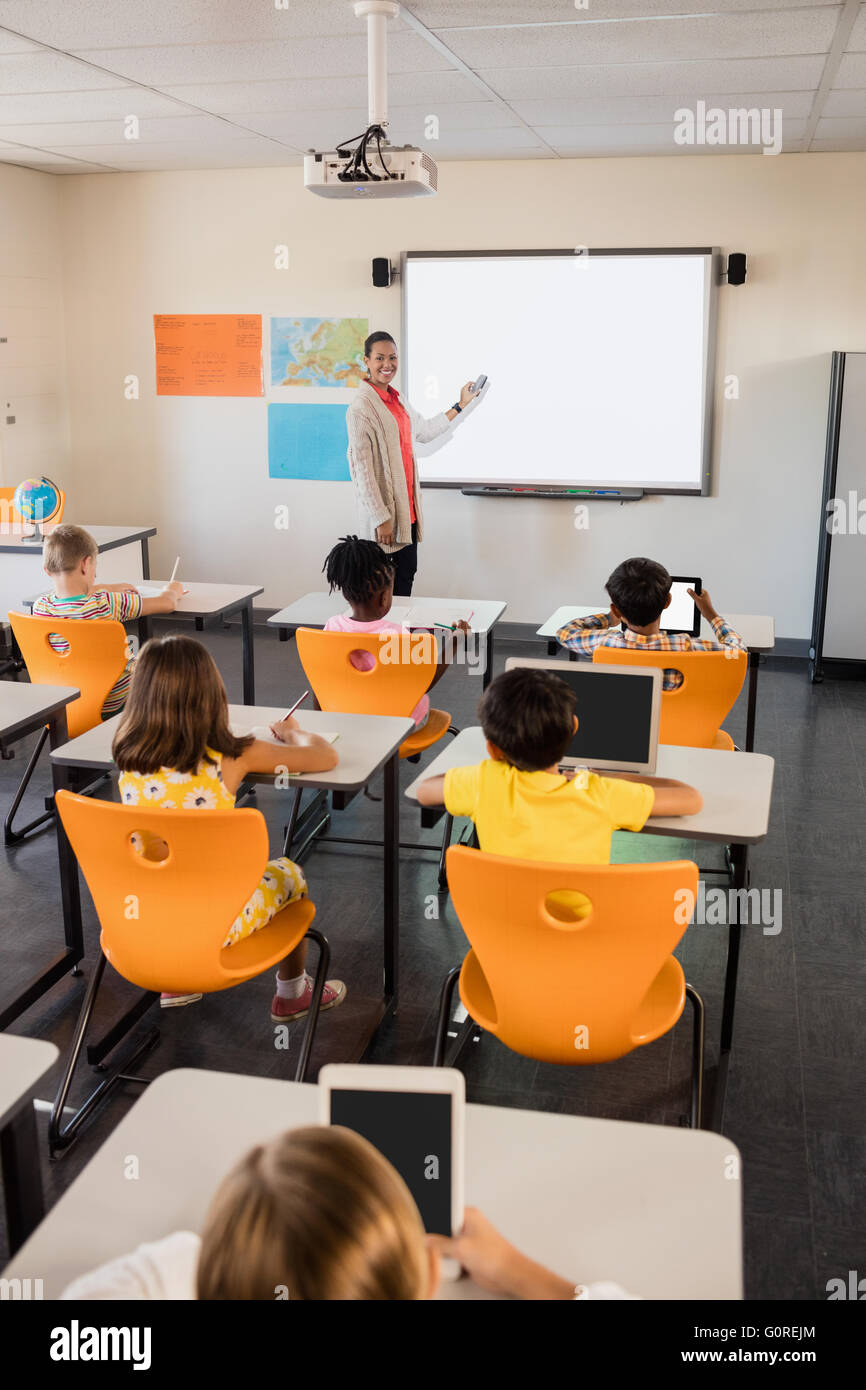 Teacher giving lesson to her students Stock Photo - Alamy