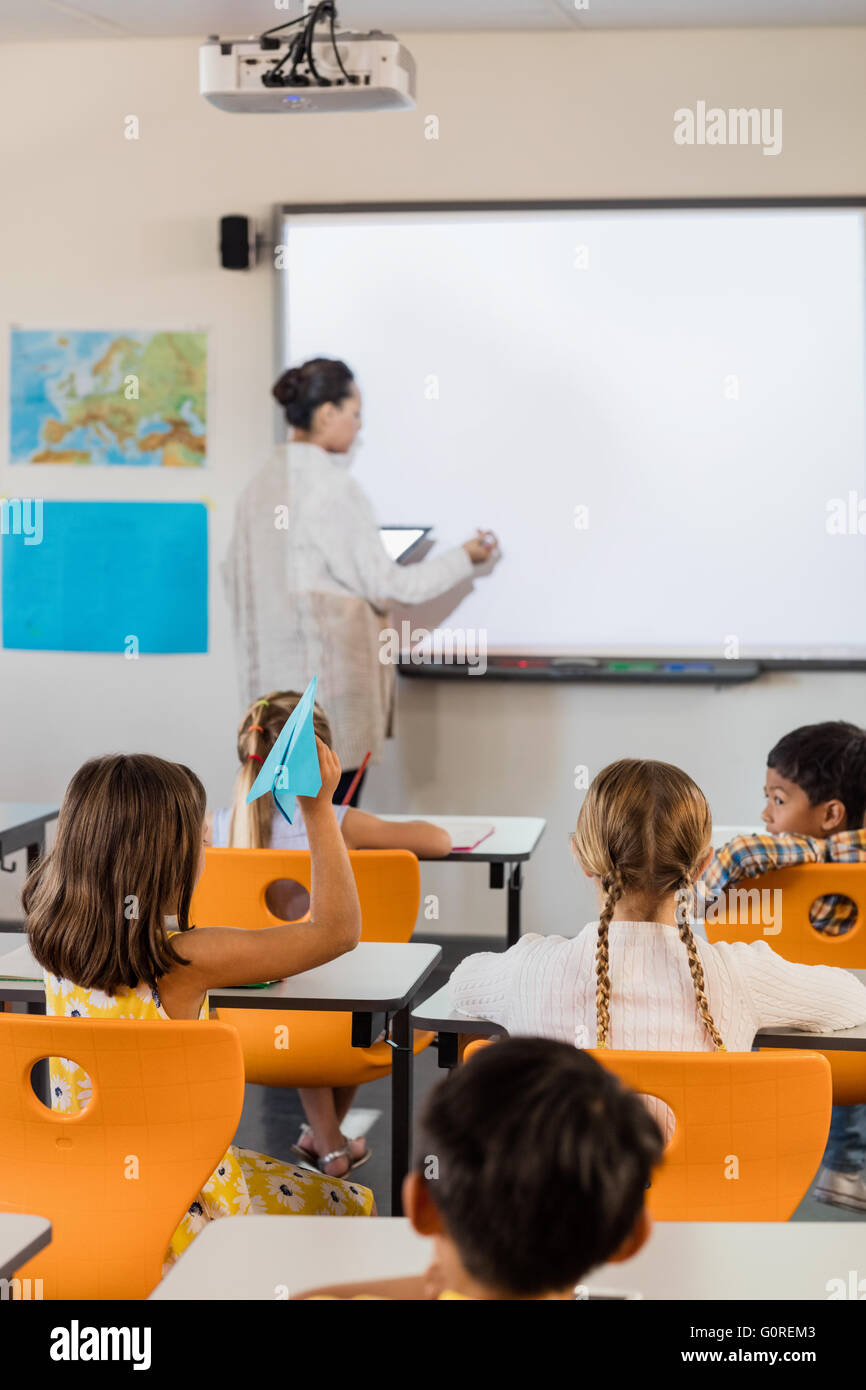 Teacher giving lesson to her students Stock Photo - Alamy