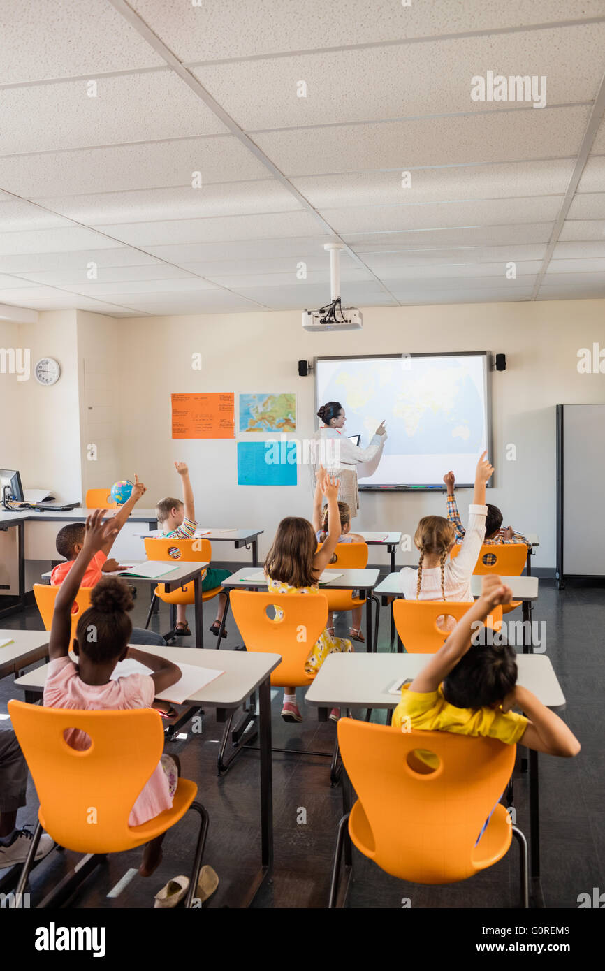 Teacher giving lesson to her students Stock Photo - Alamy