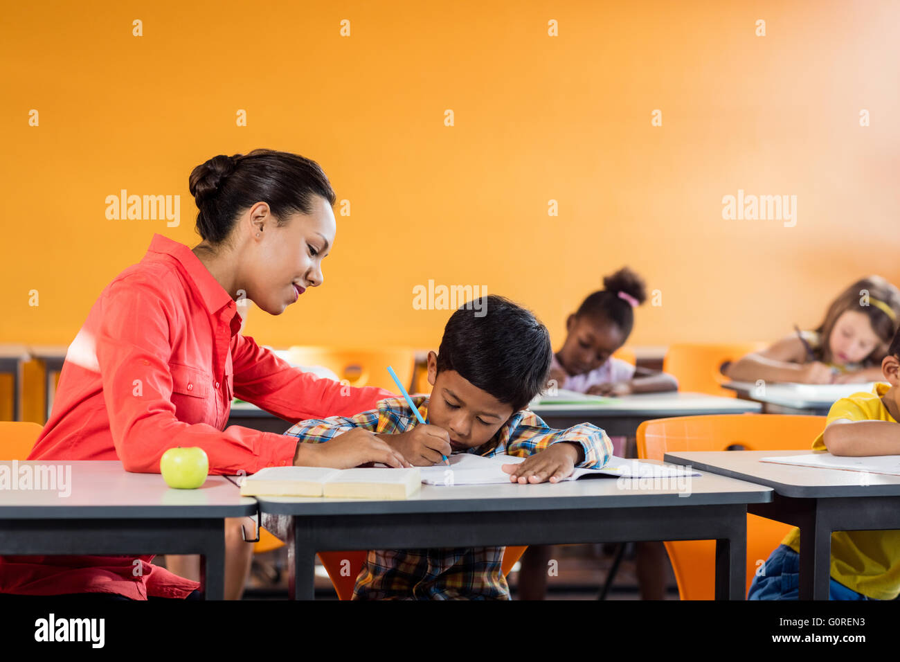 Teacher giving lesson to her students Stock Photo - Alamy