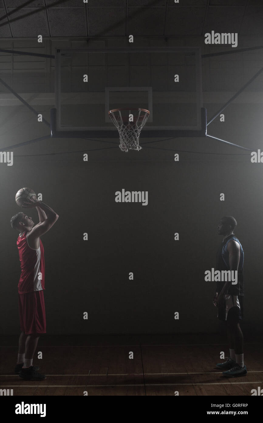 Two basketball player in a gymnasium with one scoring a shoot Stock ...