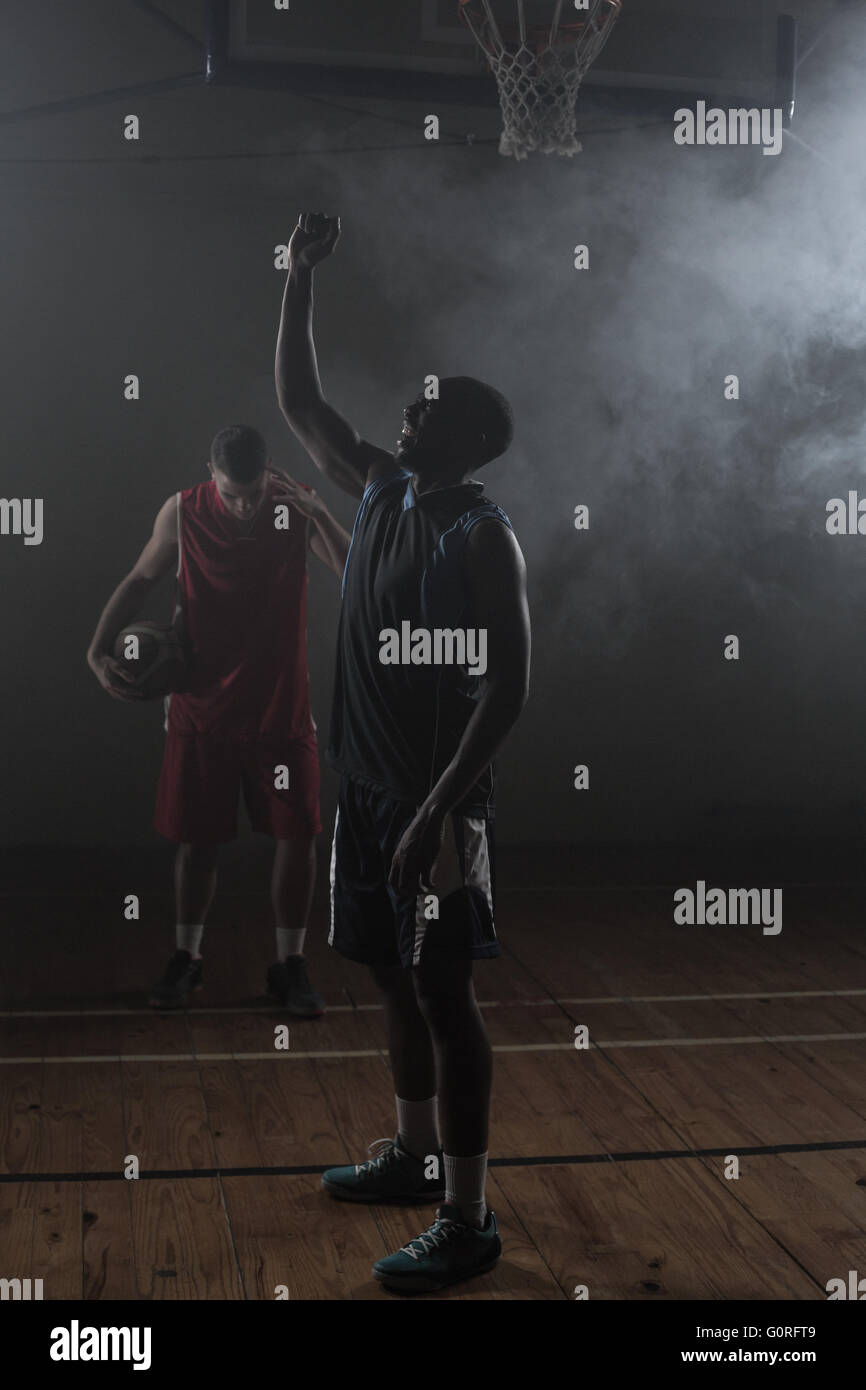 Victorious basketball player raising his arms up Stock Photo - Alamy