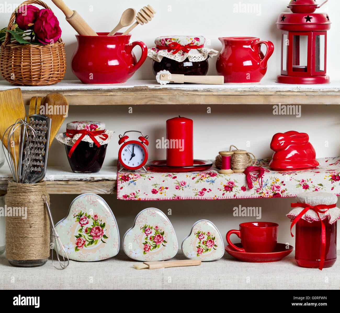 A rustic style. Ceramic tableware and kitchenware in red on the shelves ...