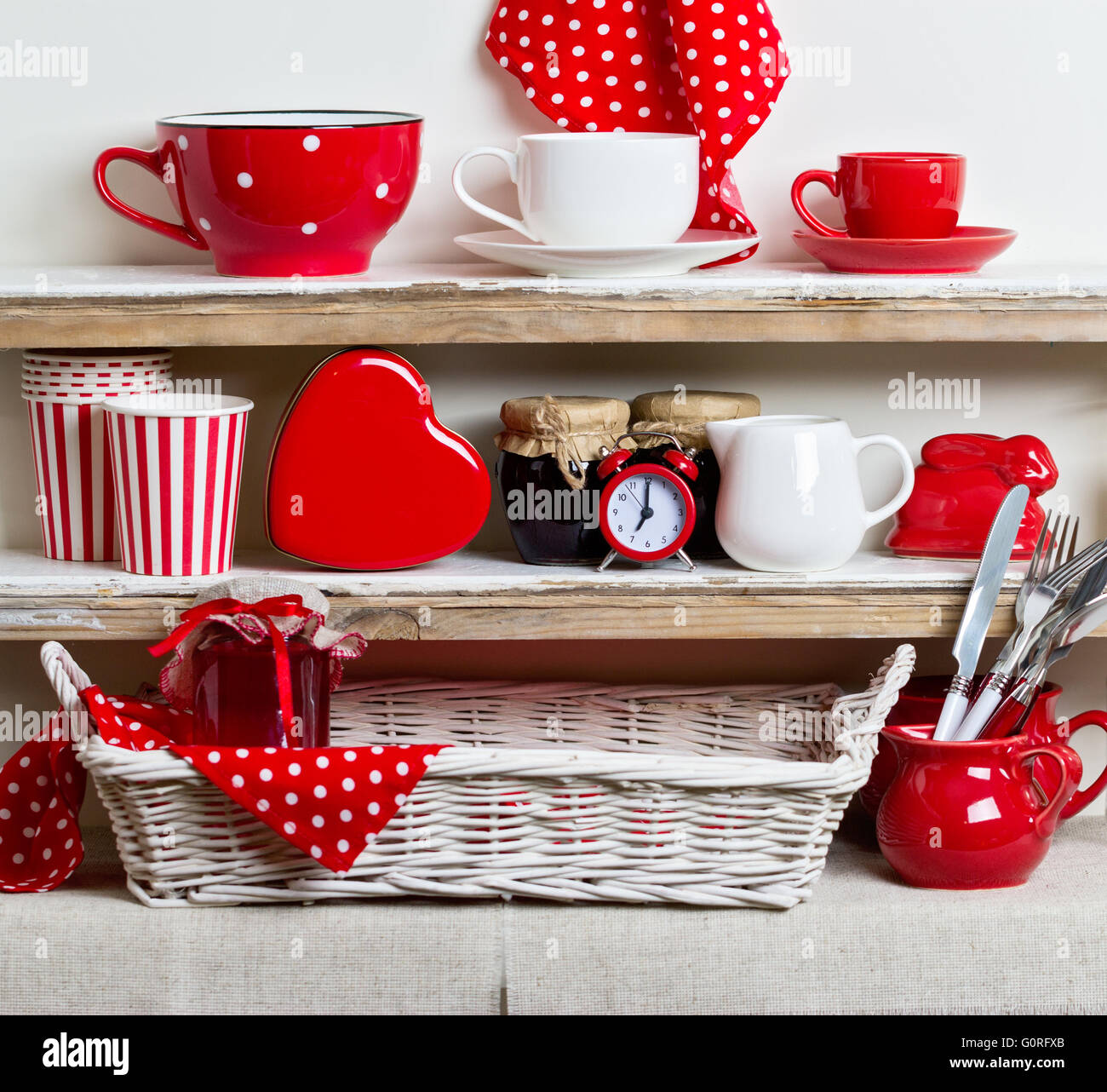 A rustic style. Ceramic tableware and kitchenware in red on the shelves ...