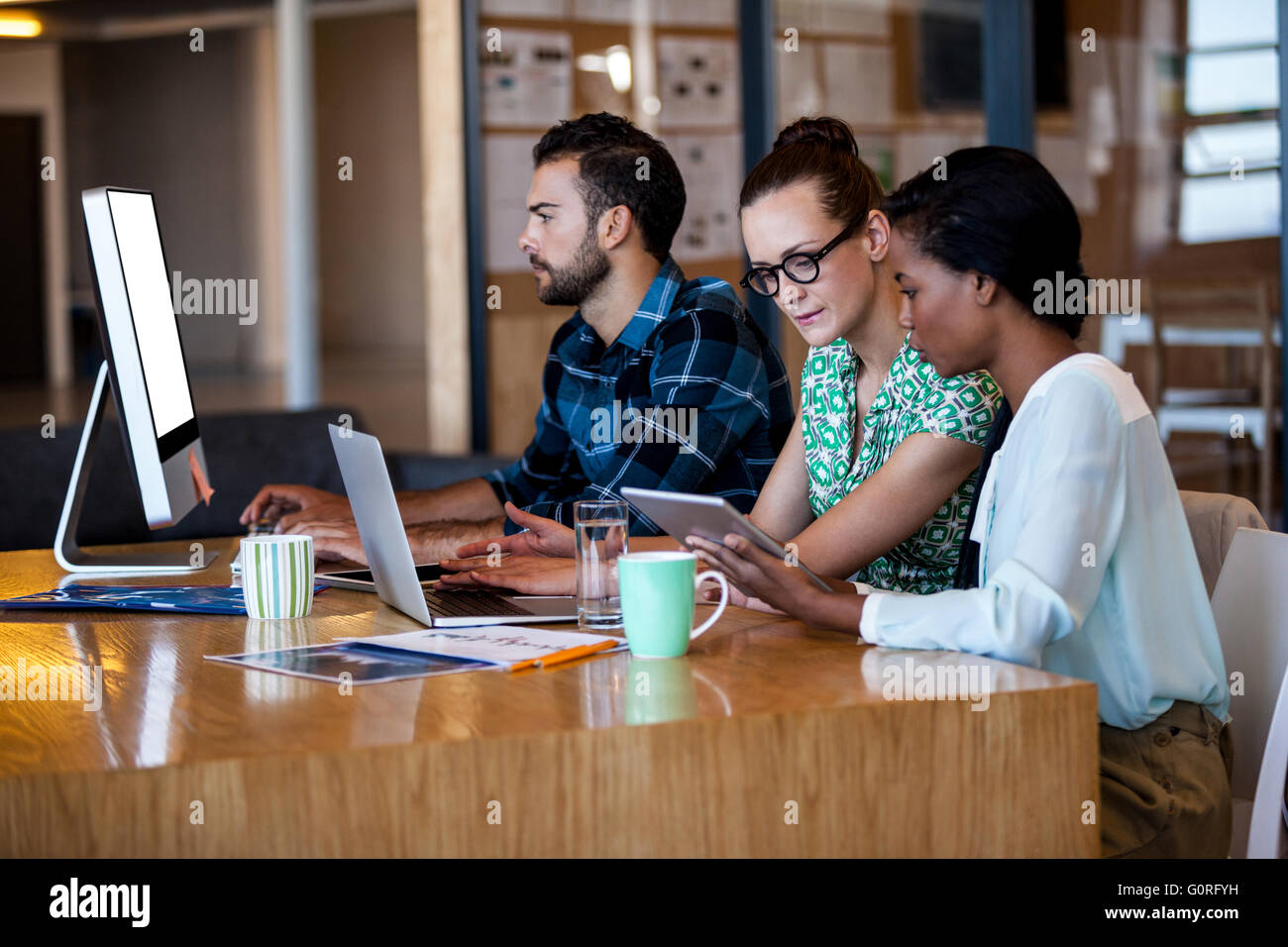 Business people sitting at computer desk Stock Photo - Alamy