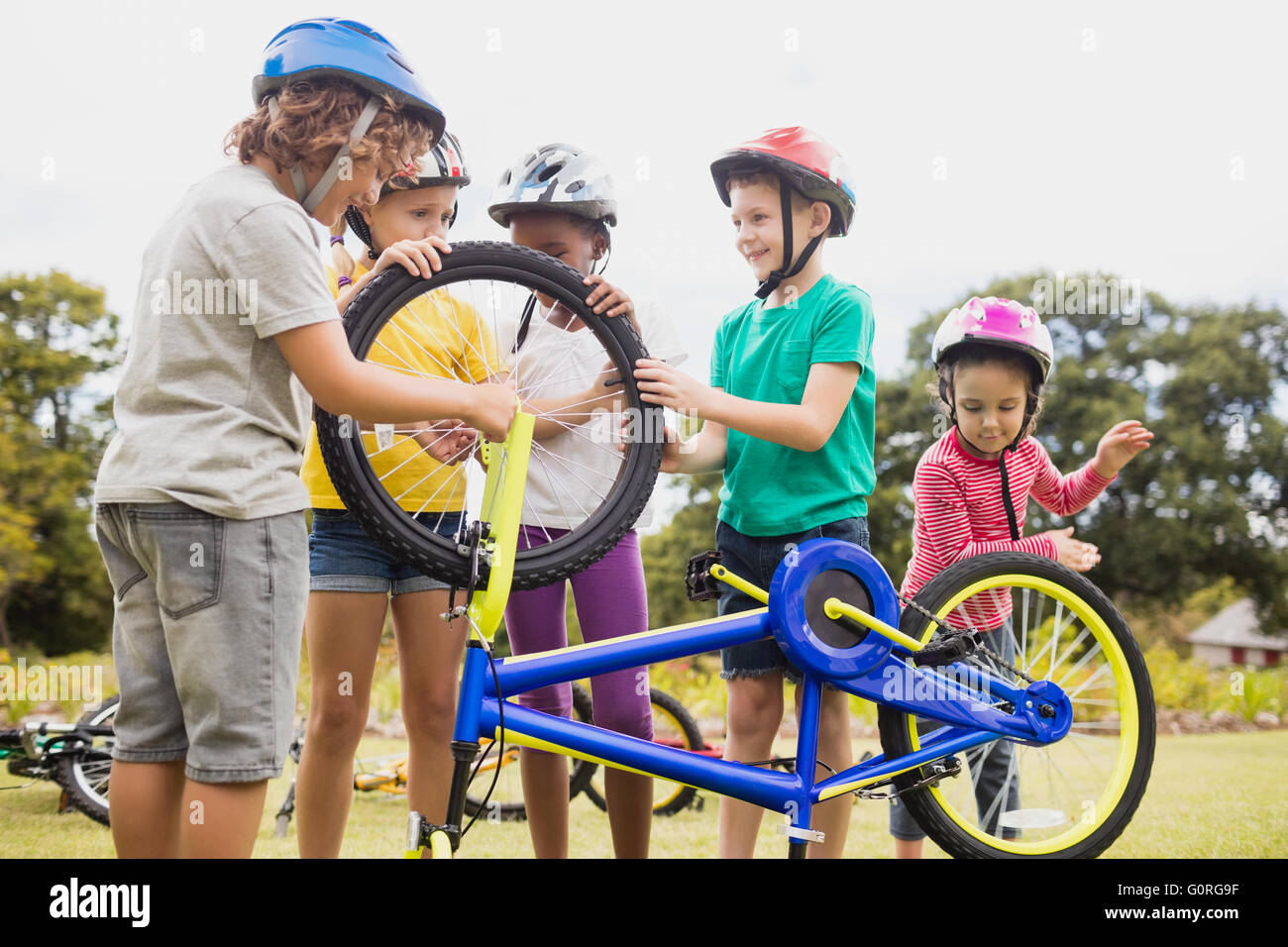 Children playing with bike in the park Stock Photo - Alamy