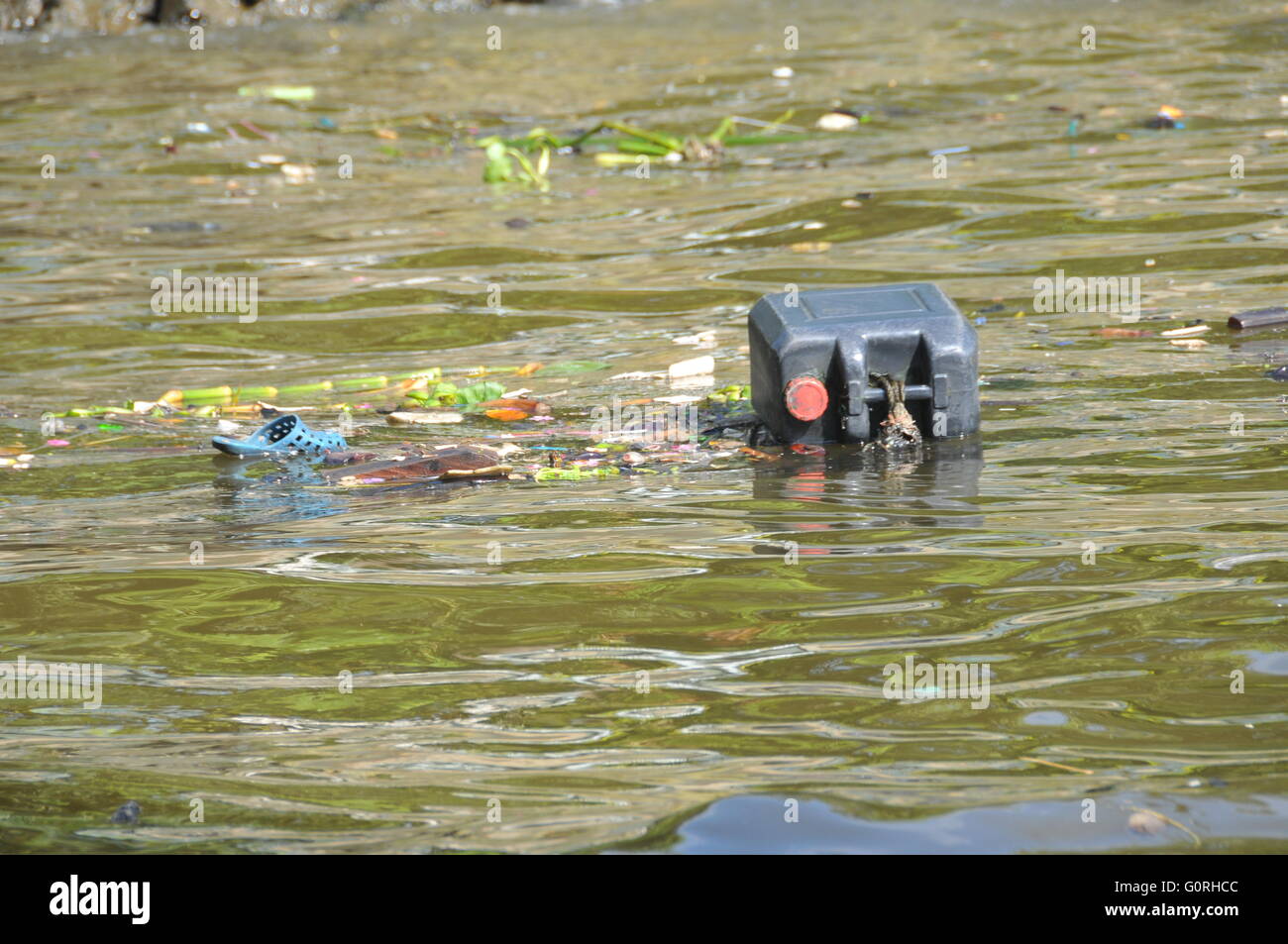 Plastic waste floating down a river causing pollution in a river in ...